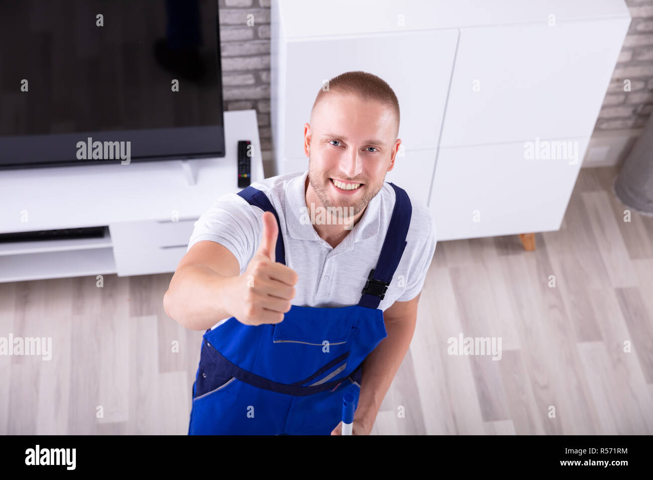 Portrait Of A Happy Male Janitor Standing In Living Room Stock Photo ...