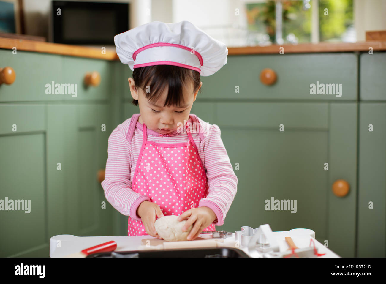 toddler baby girl pretend play baking bread Stock Photo - Alamy
