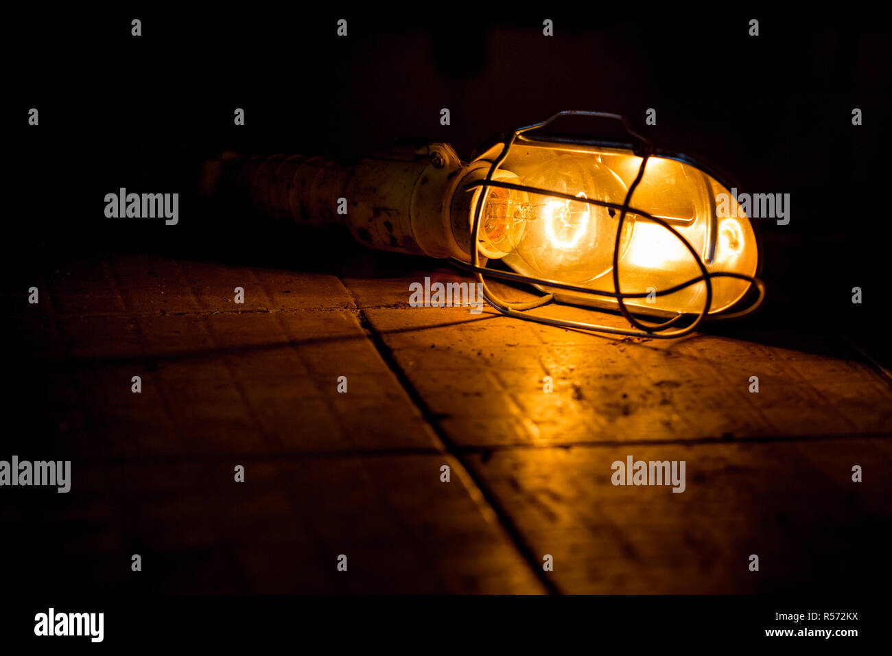 Light bulb in metal case on tiles in car mechanic workshop Stock Photo ...
