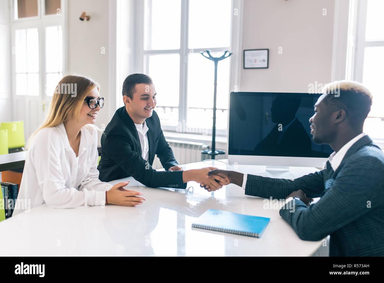 Shot of an investment advisor shaking hands with smiling man while ...
