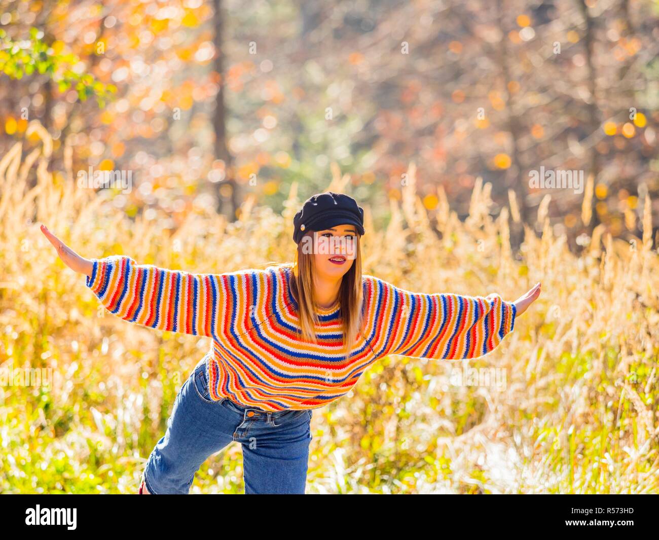 Young Woman Teen Girl Female Adolescent And Warm Autumn Colors In Nature Standing On One Leg