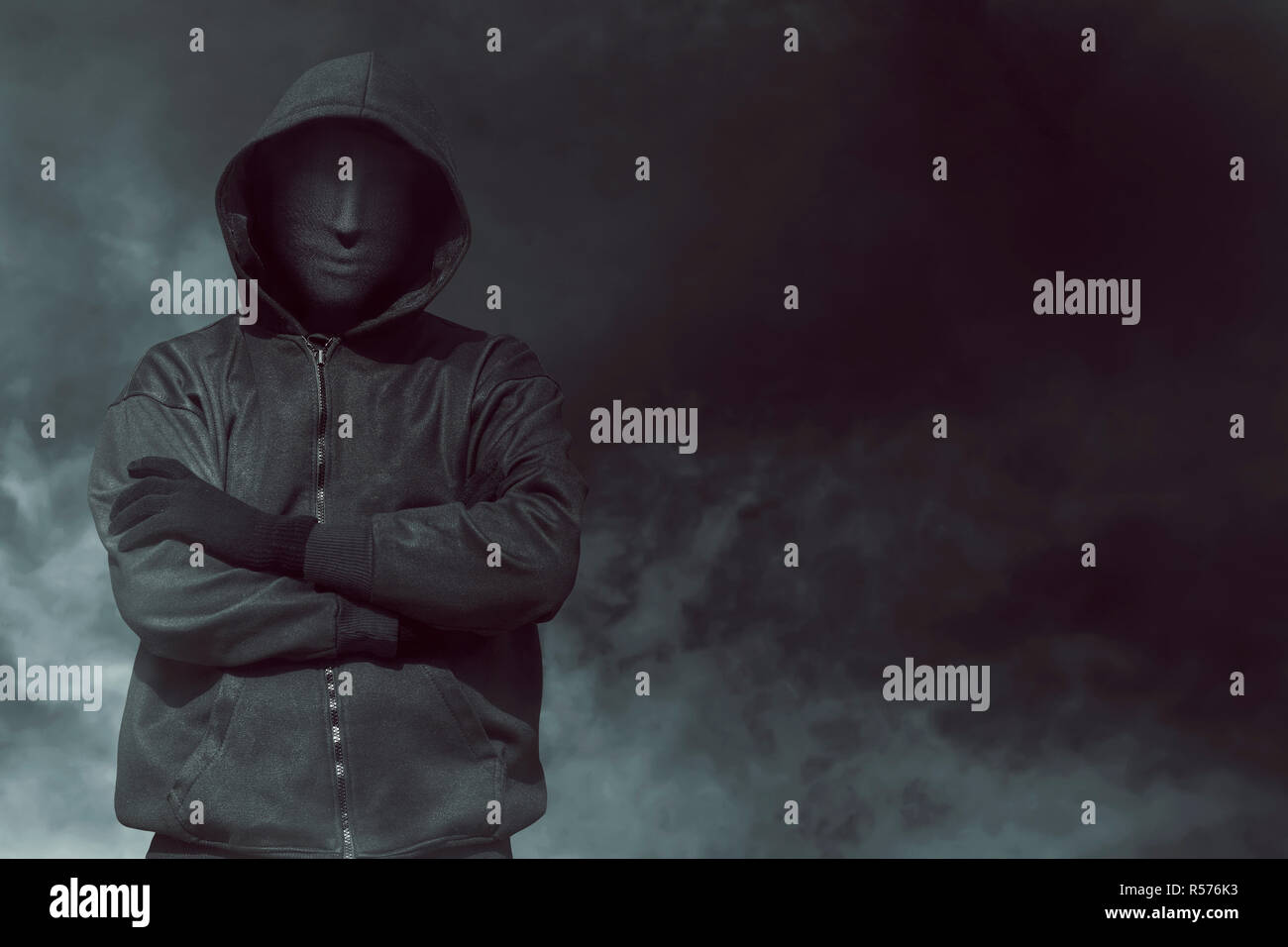 Hooded man with mask standing alone Stock Photo - Alamy