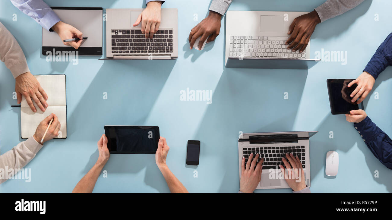 Group Of Hands On Desk Stock Photo - Alamy