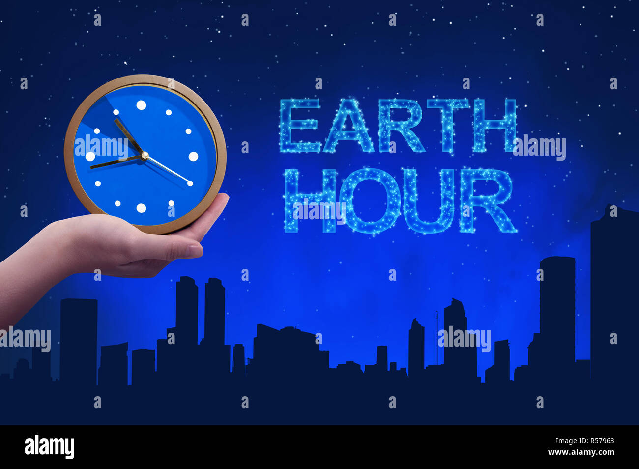 People hand holding a clock with earth hour greeting Stock Photo - Alamy