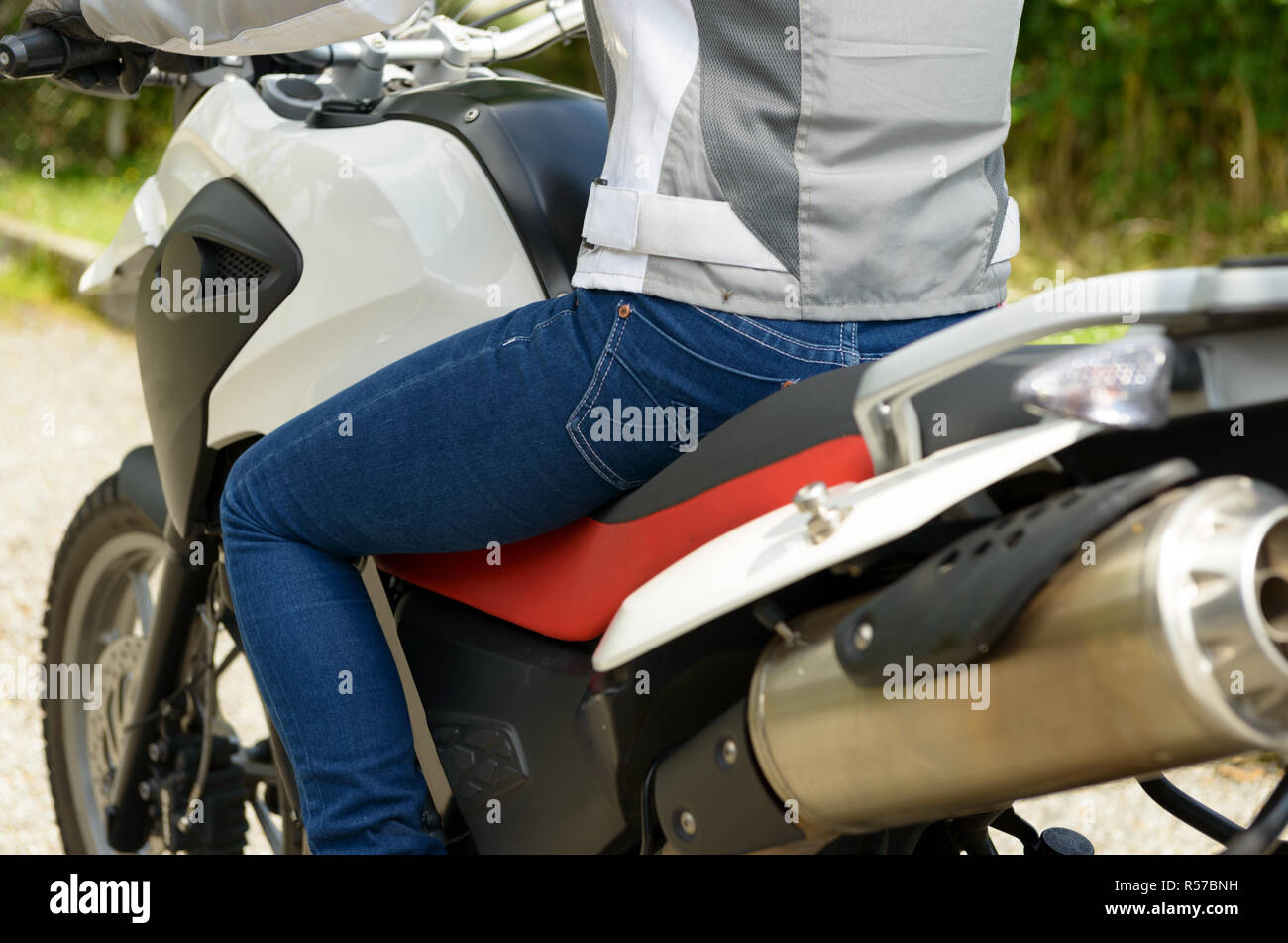 Female legs wearing blue jeans sitting on motorcycle Stock Photo - Alamy