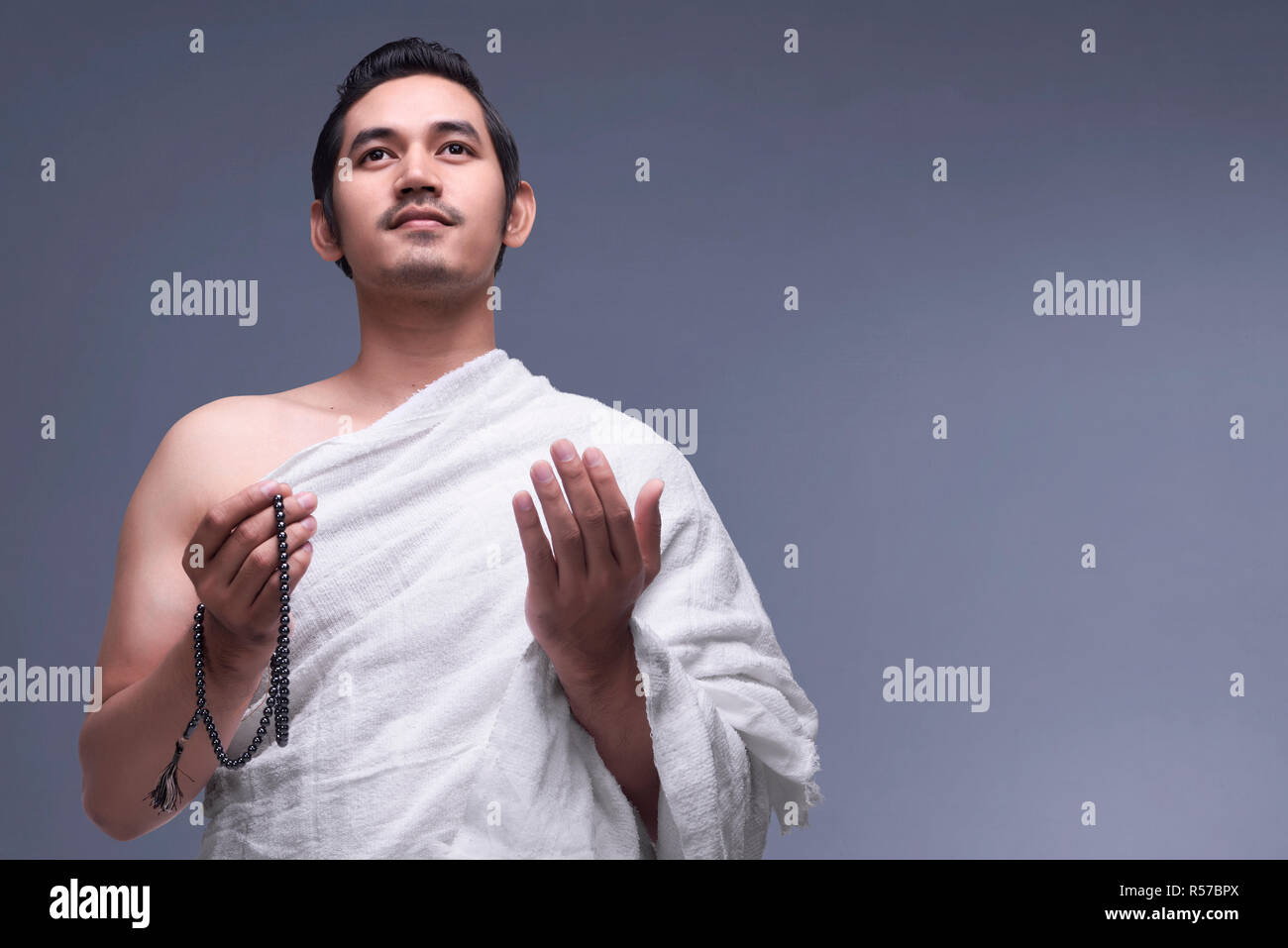 Young asian muslim man wearing ihram clothes with prayer beads Stock ...