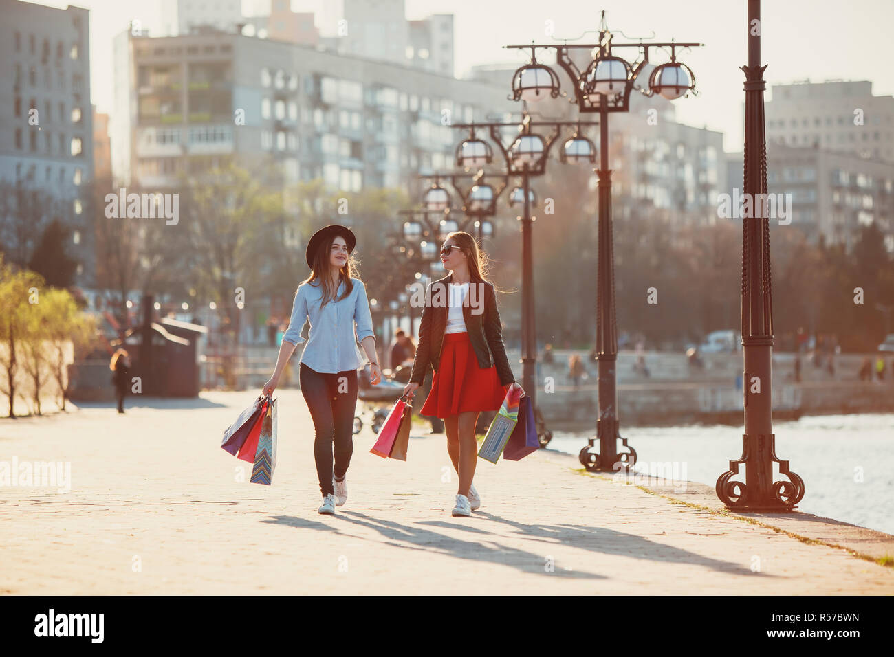 Two girls walking with shopping on city streets Stock Photo - Alamy
