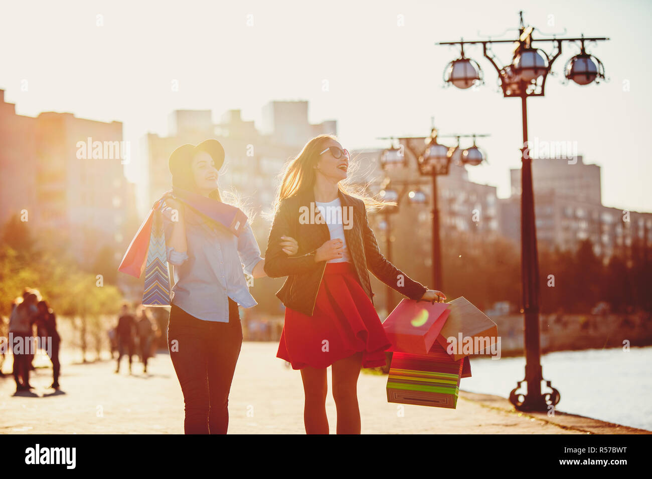 Two girls walking with shopping on city streets Stock Photo - Alamy