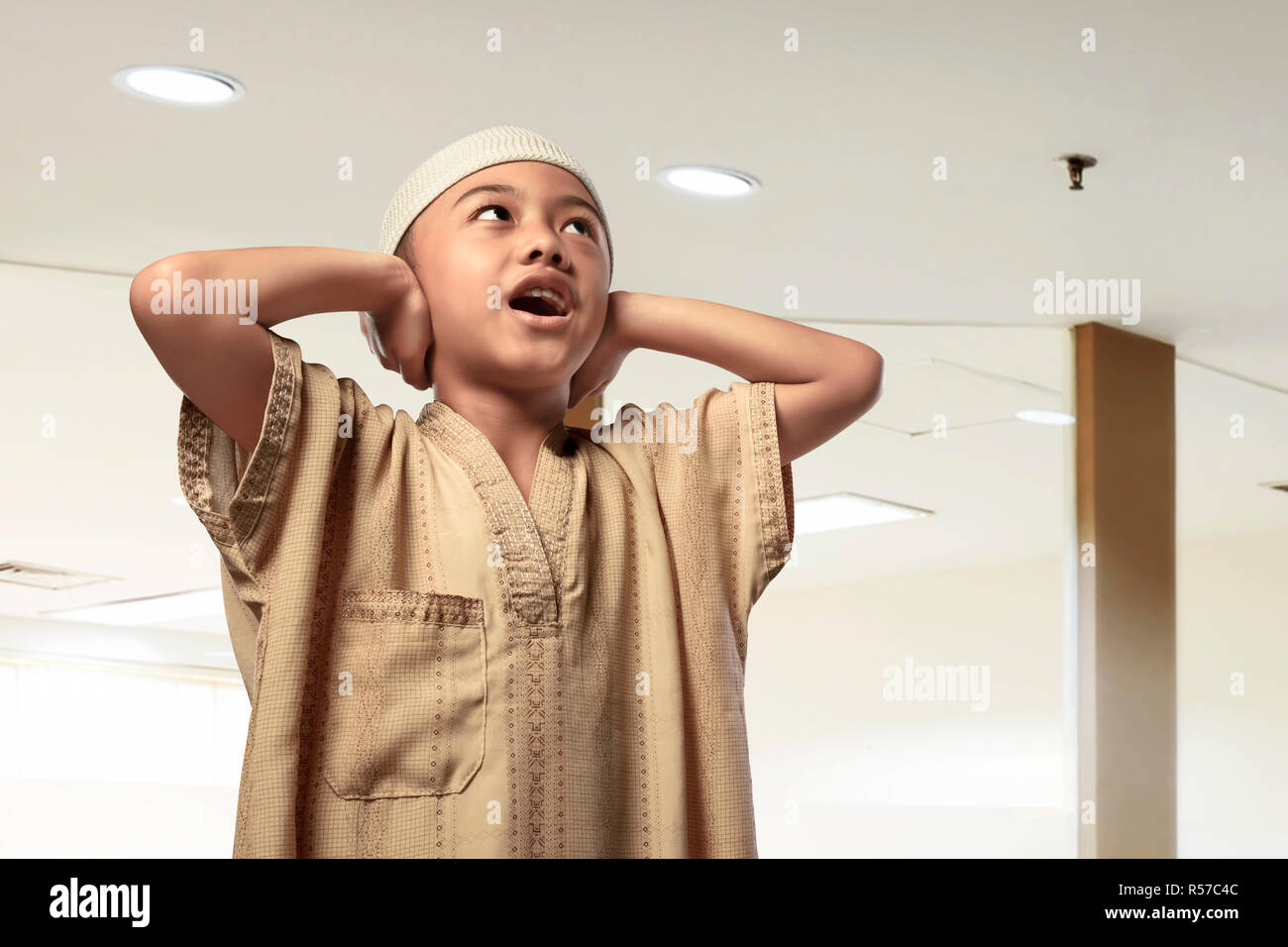 Religious asian muslim kid with cap praying Stock Photo - Alamy