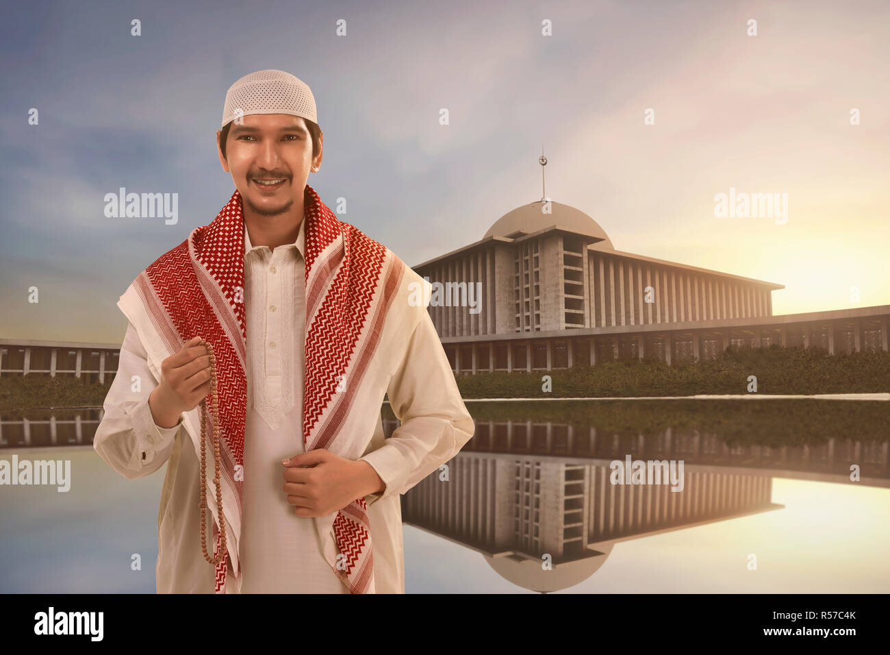 Handsome asian muslim man with traditional dress holding prayer beads ...