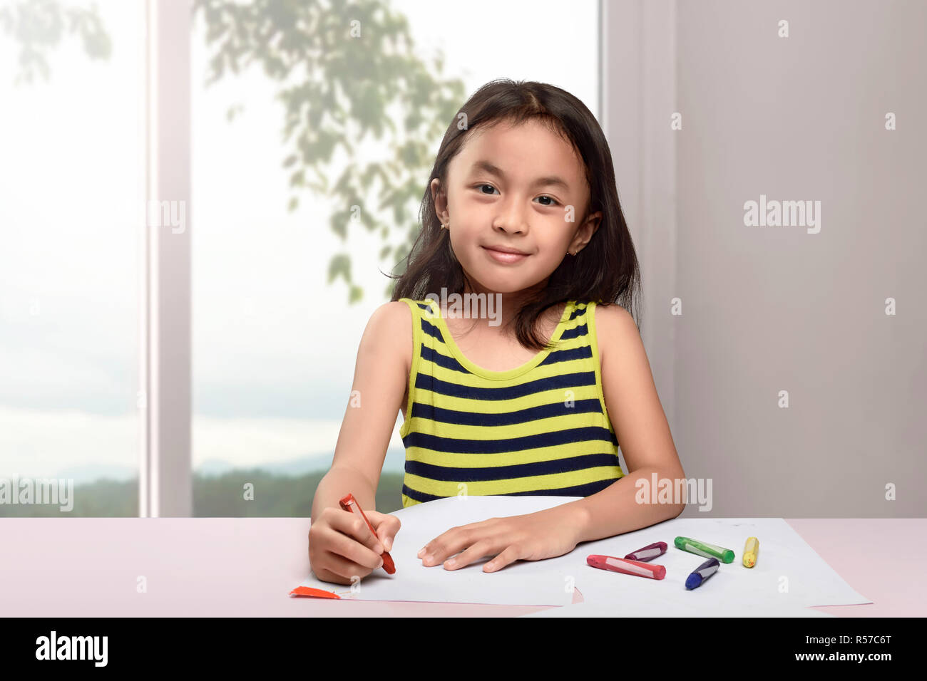 Happy asian child drawing with crayon on white paper Stock Photo - Alamy