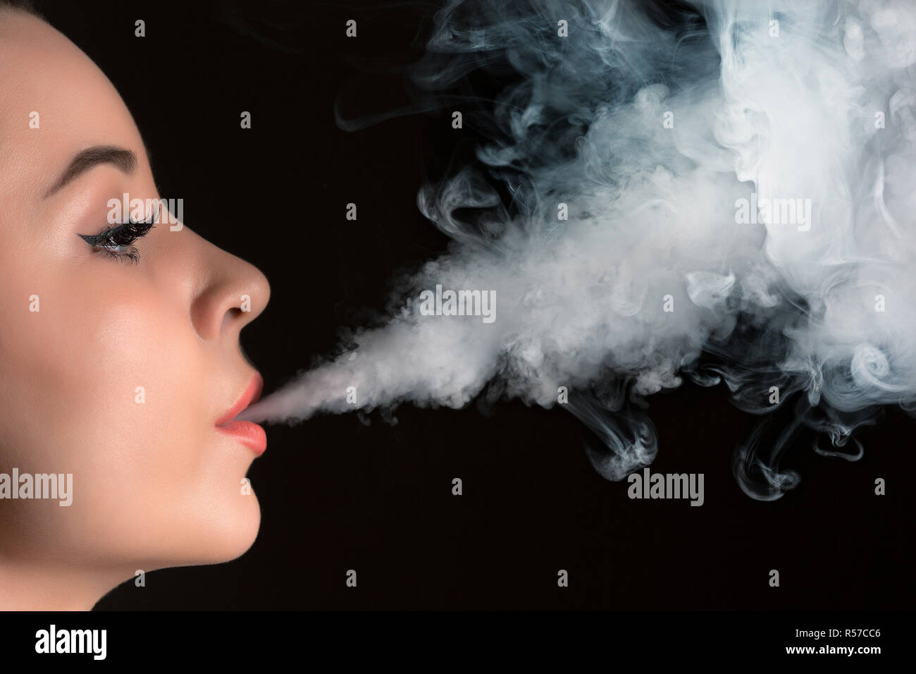 The face of vaping young woman at black studio Stock Photo - Alamy