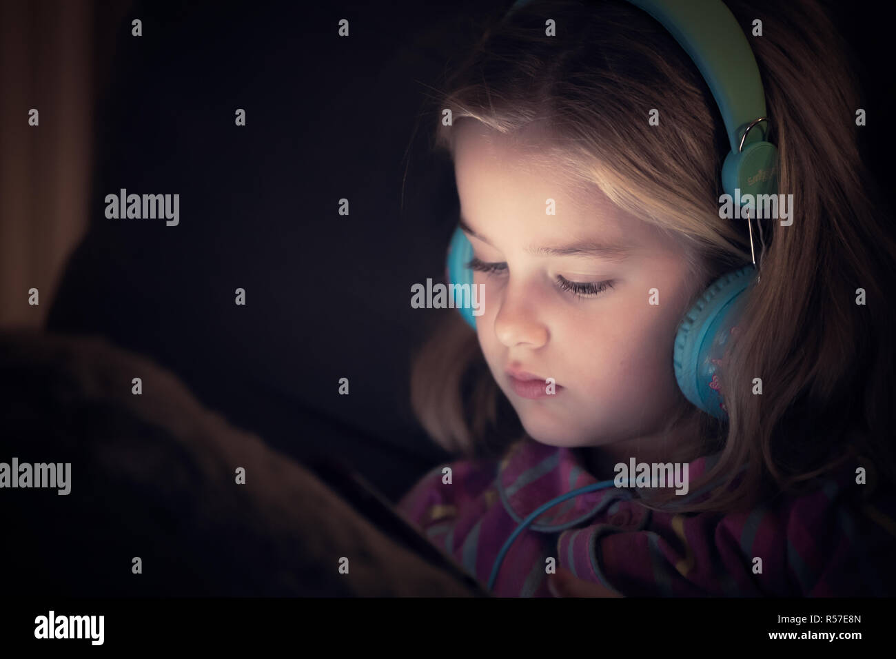 Child watching her tablet Stock Photo - Alamy