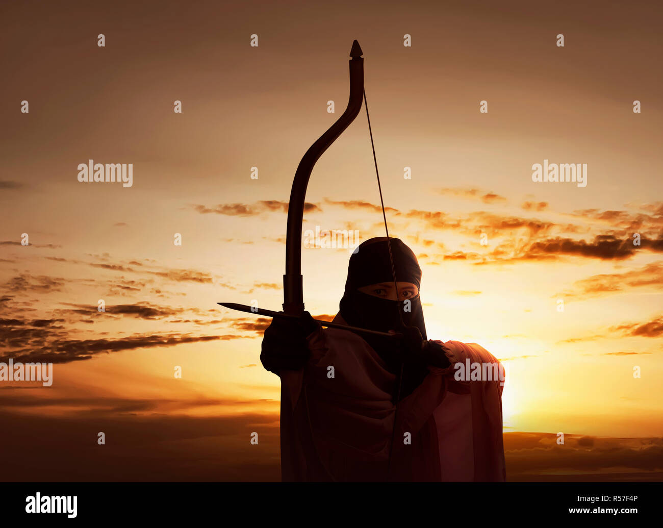 Asian muslim woman wearing hijab holding bow to shoot an arrow Stock ...