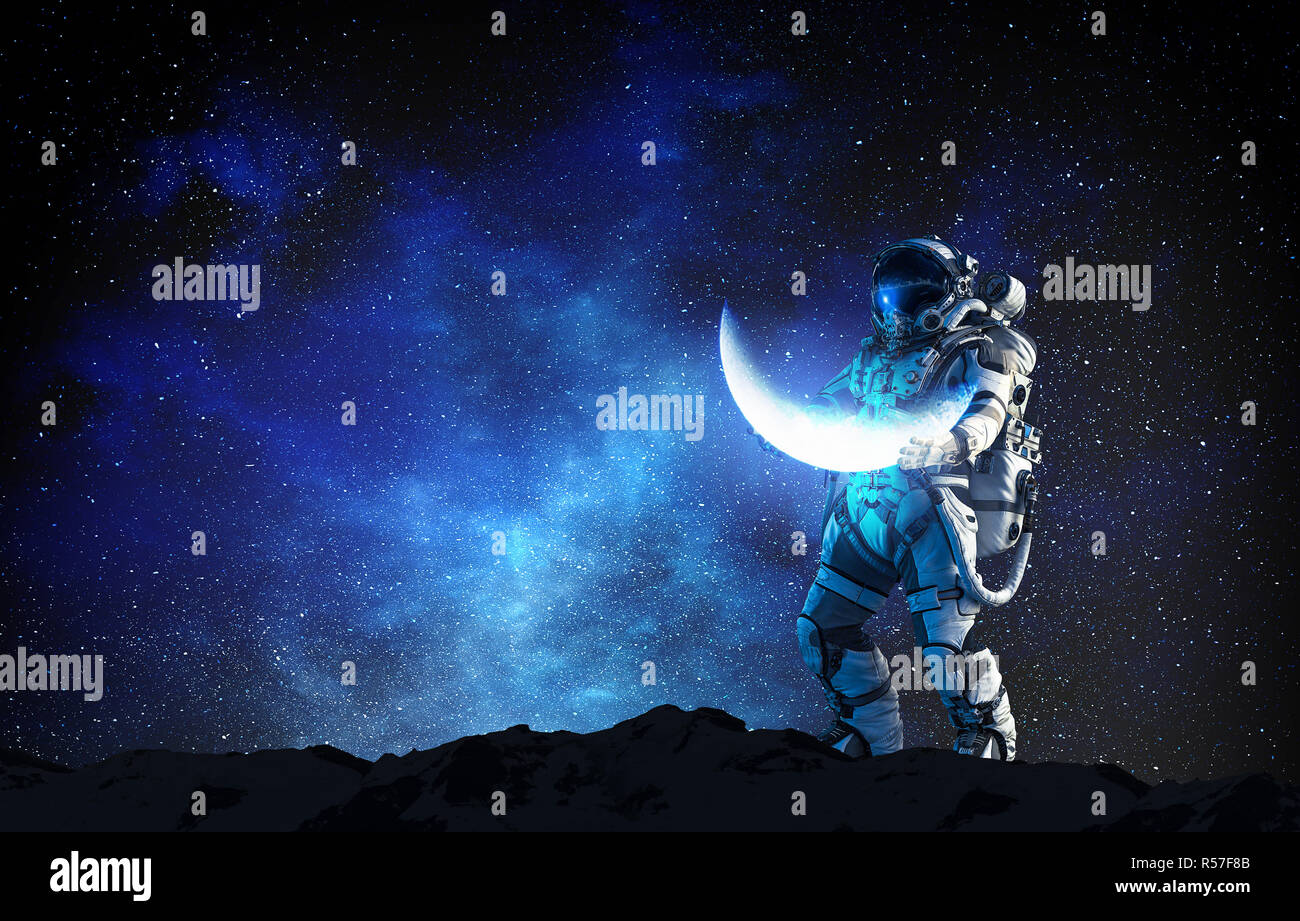Spaceman carry moon planet. Mixed media Stock Photo - Alamy