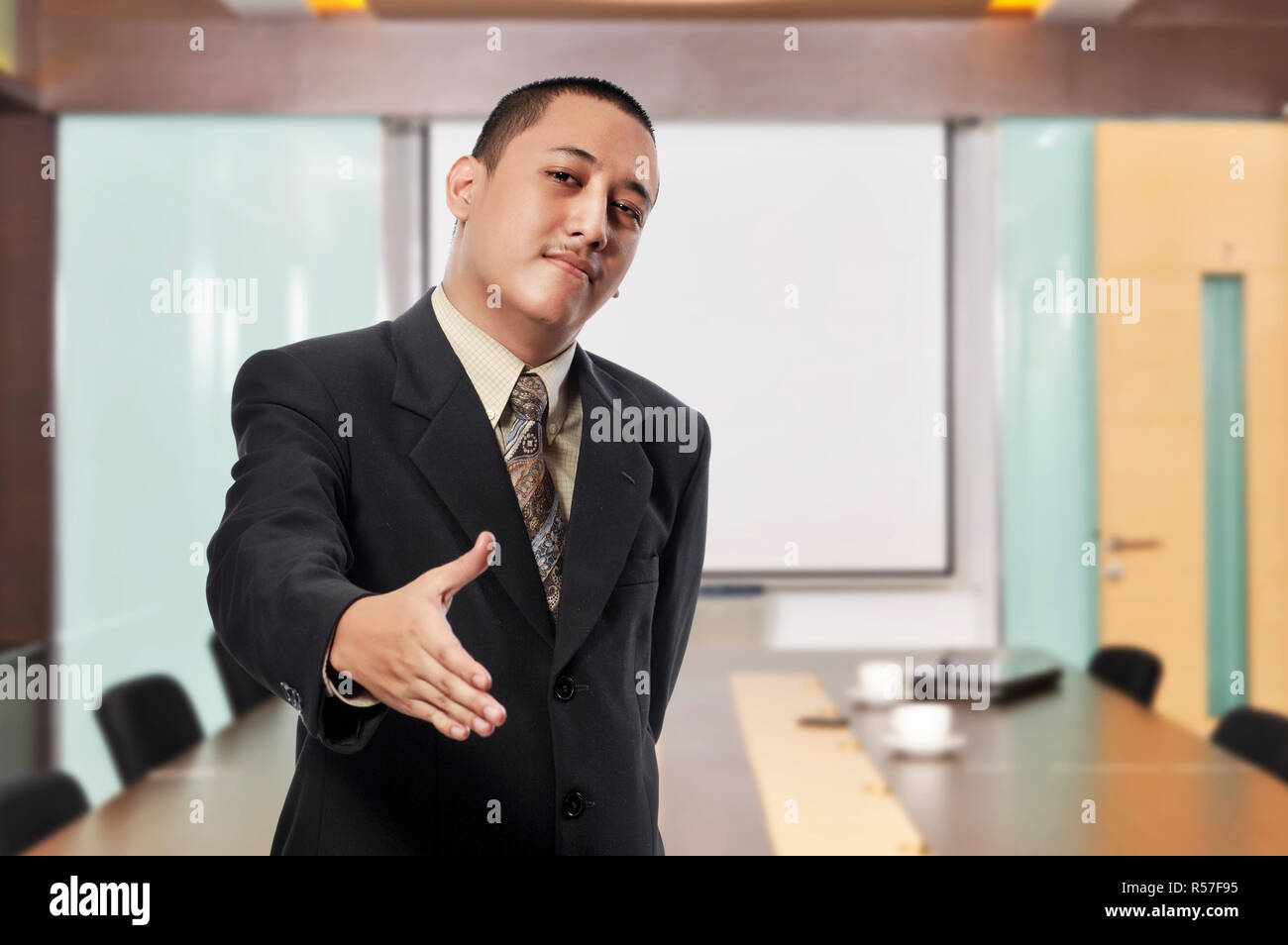 Smiling businessman with open hand ready to hand shake Stock Photo - Alamy