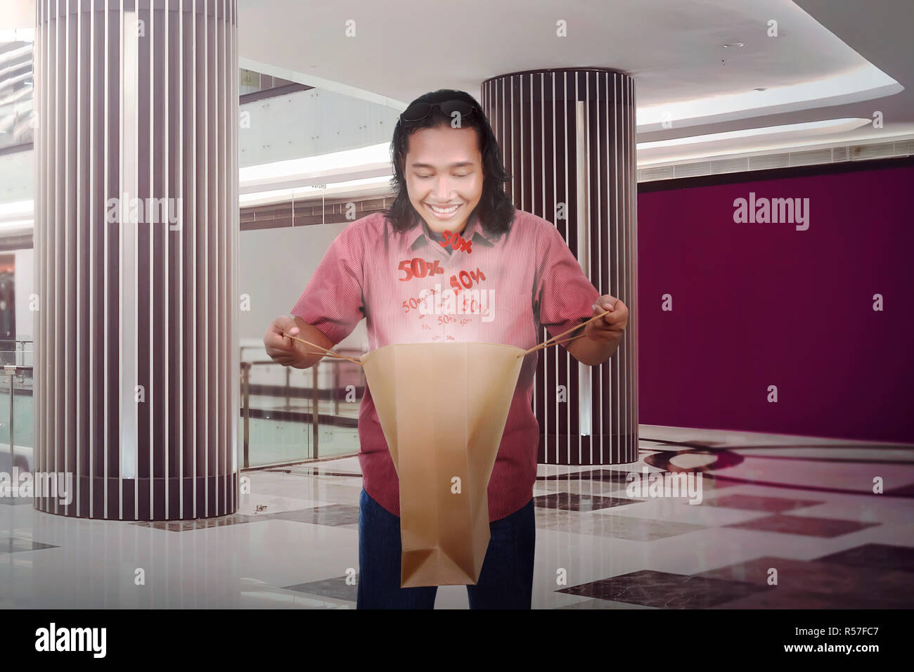 Shocking long haired man open shopping bag Stock Photo - Alamy