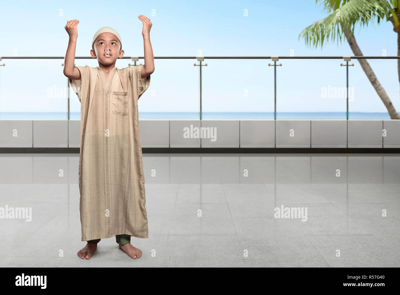 Asian muslim kid with cap raising hand and praying Stock Photo - Alamy