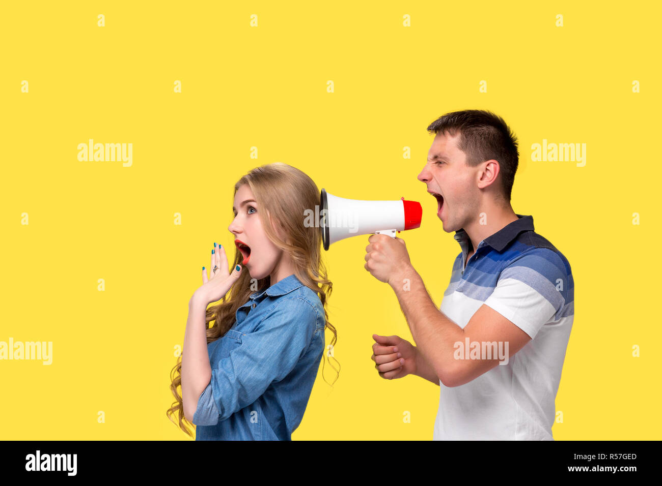 Man shouting in megaphones at each other Stock Photo - Alamy