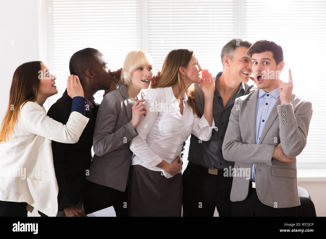 Secretive Business Colleagues Whispering In The Office Stock Photo - Alamy
