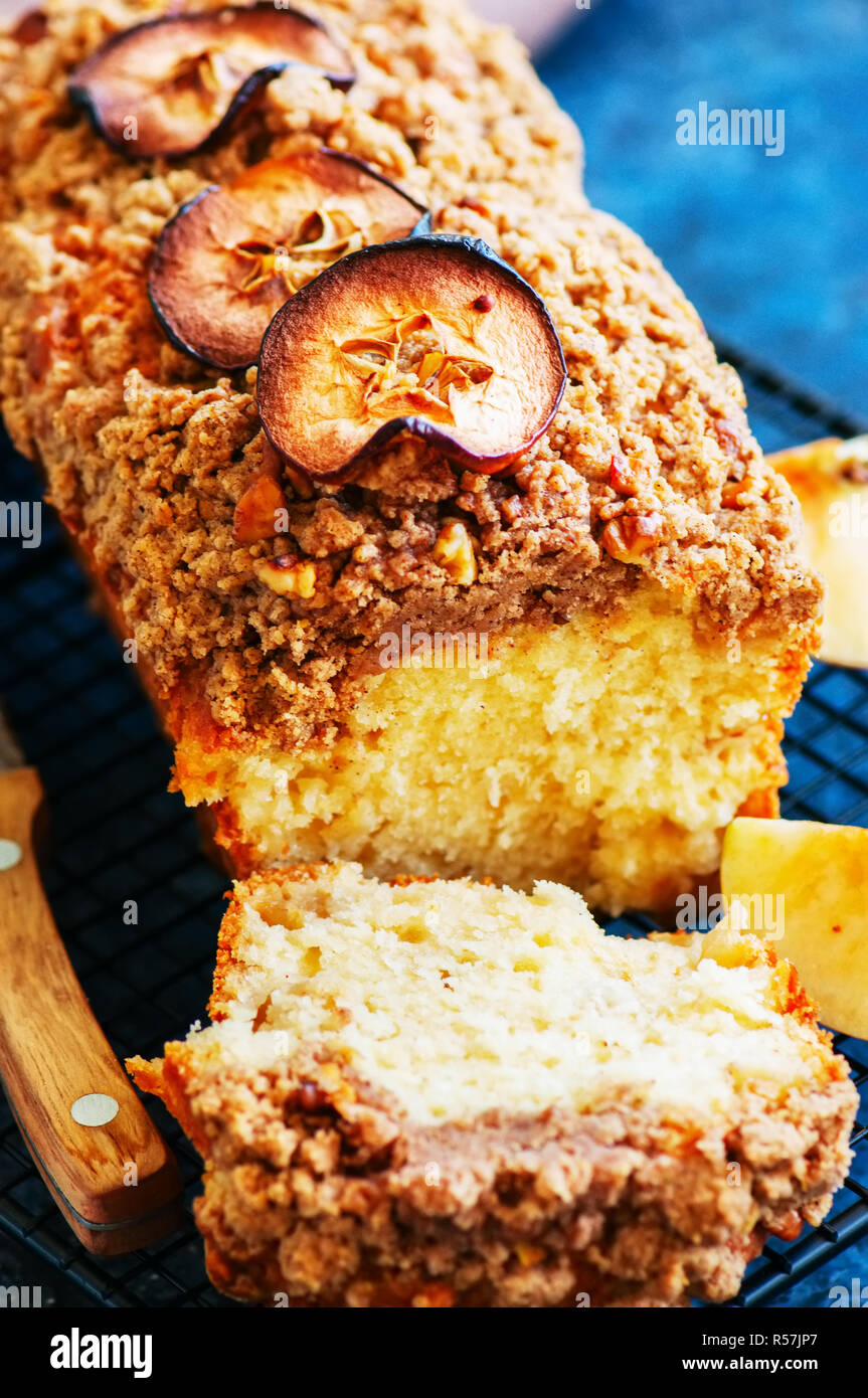Homemade apple crumble cake served on a wire rack on a white stone ...