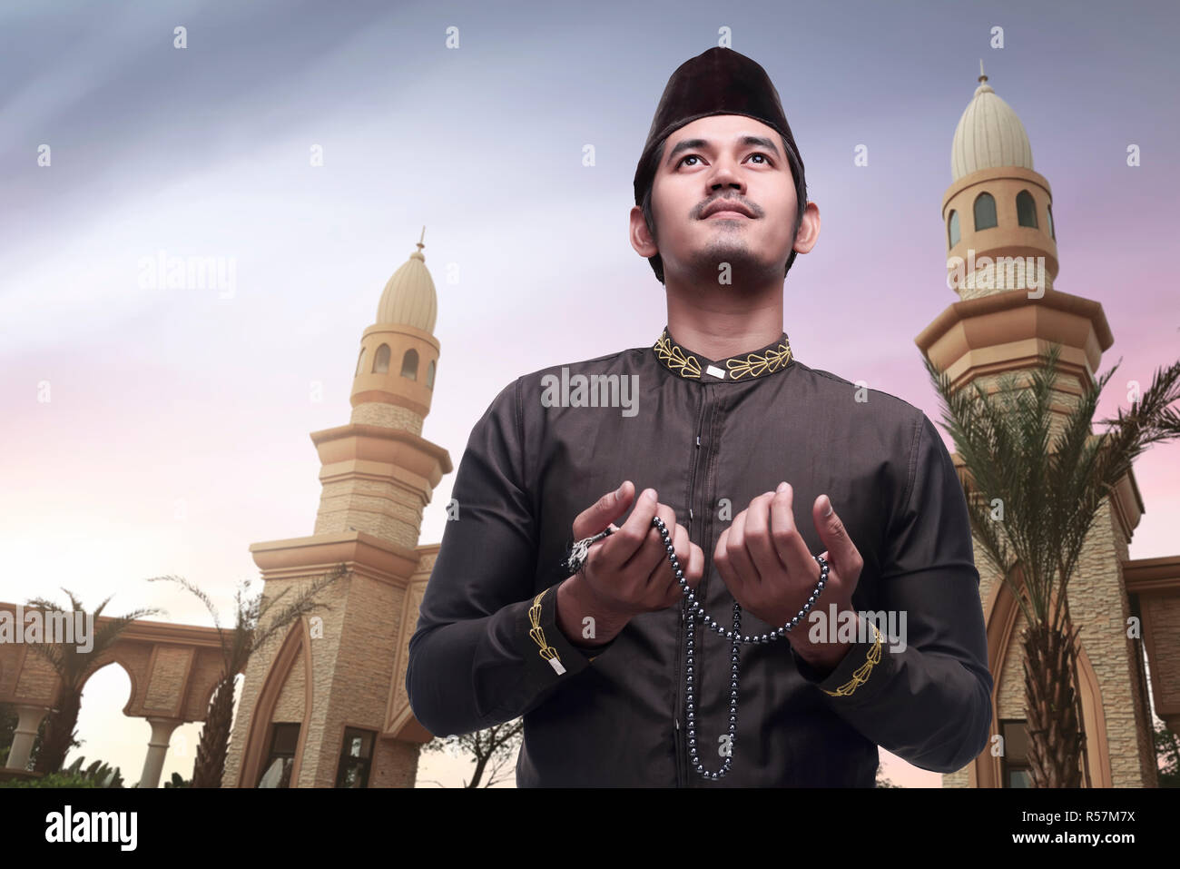 Handsome asian muslim man holding prayer beads and praying Stock Photo ...