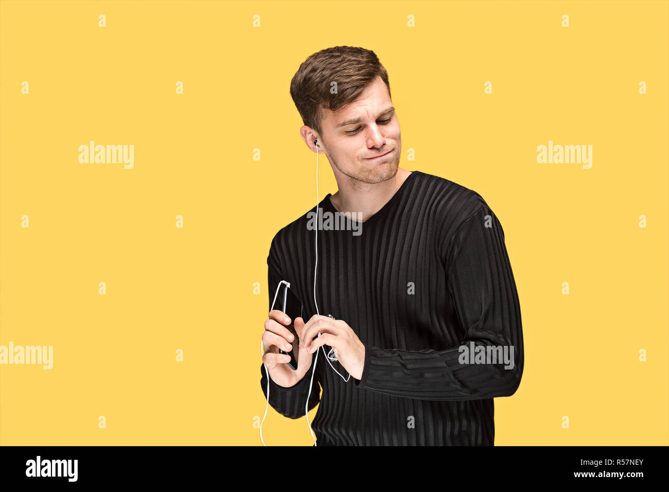 The handsome young man standing and listening music Stock Photo - Alamy