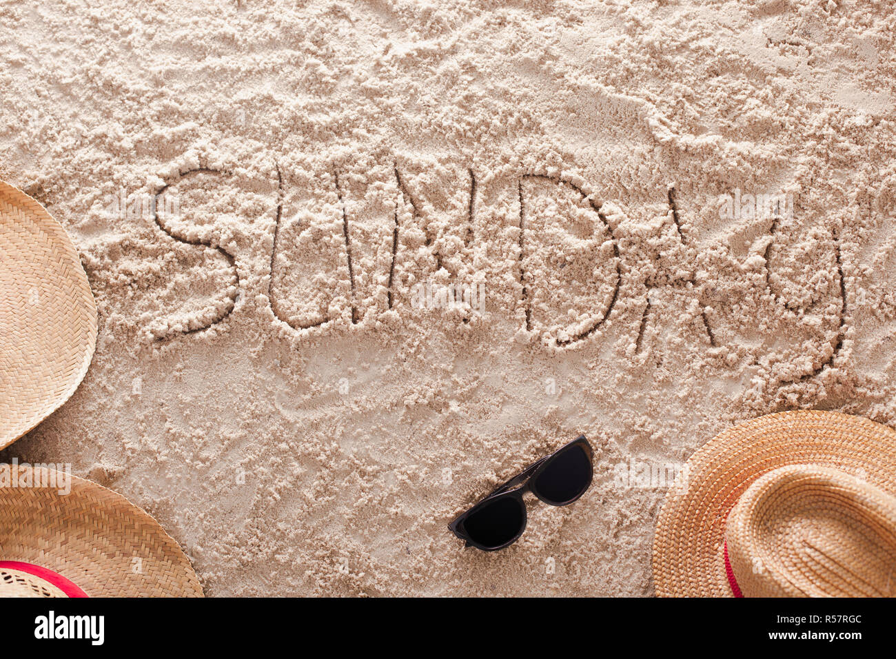 Sunday written in a sandy tropical beach Stock Photo - Alamy