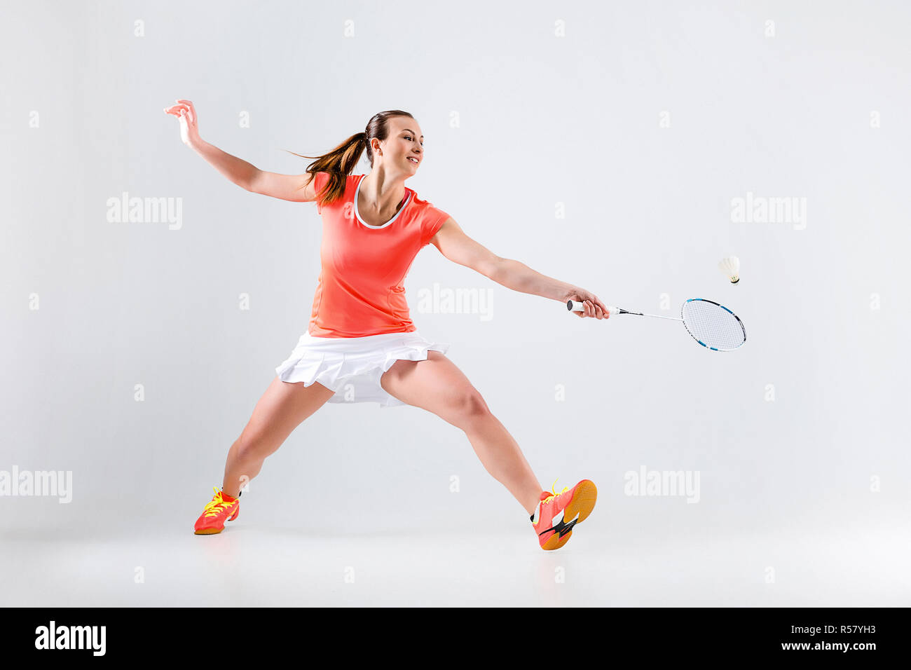 Young woman playing badminton over white background Stock Photo - Alamy