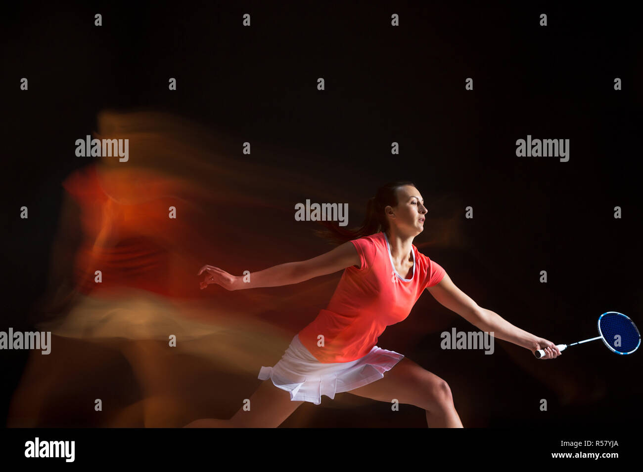 Young woman playing badminton over black background Stock Photo - Alamy