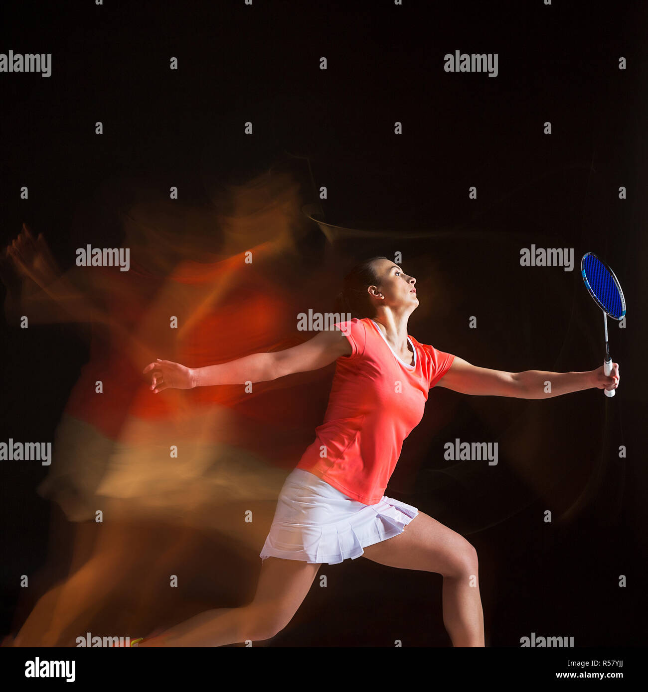 Young woman playing badminton over black background Stock Photo - Alamy