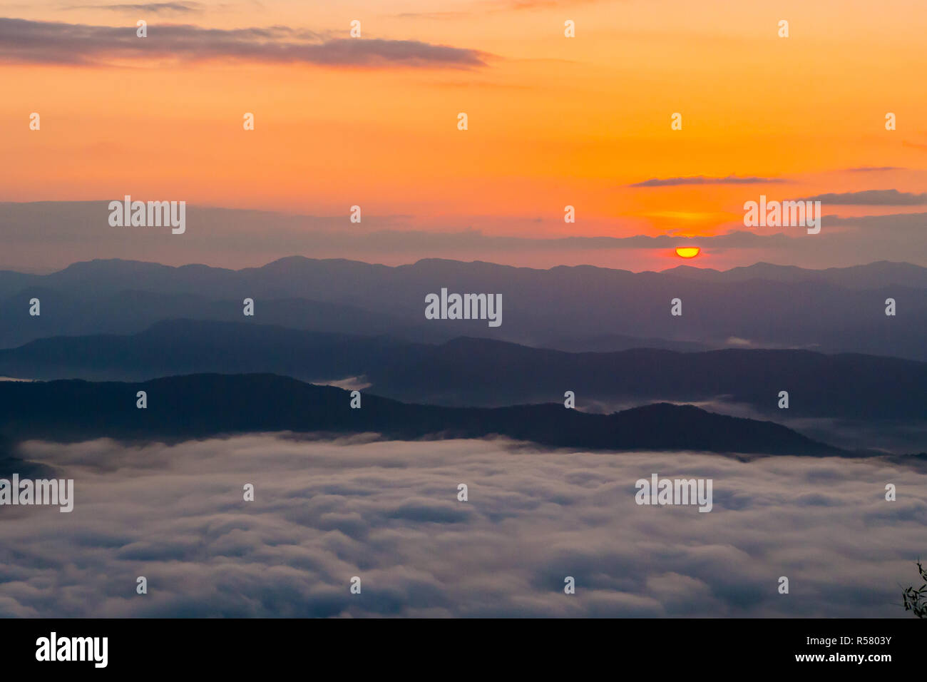 sunset overlooking mountains with Mist Stock Photo - Alamy