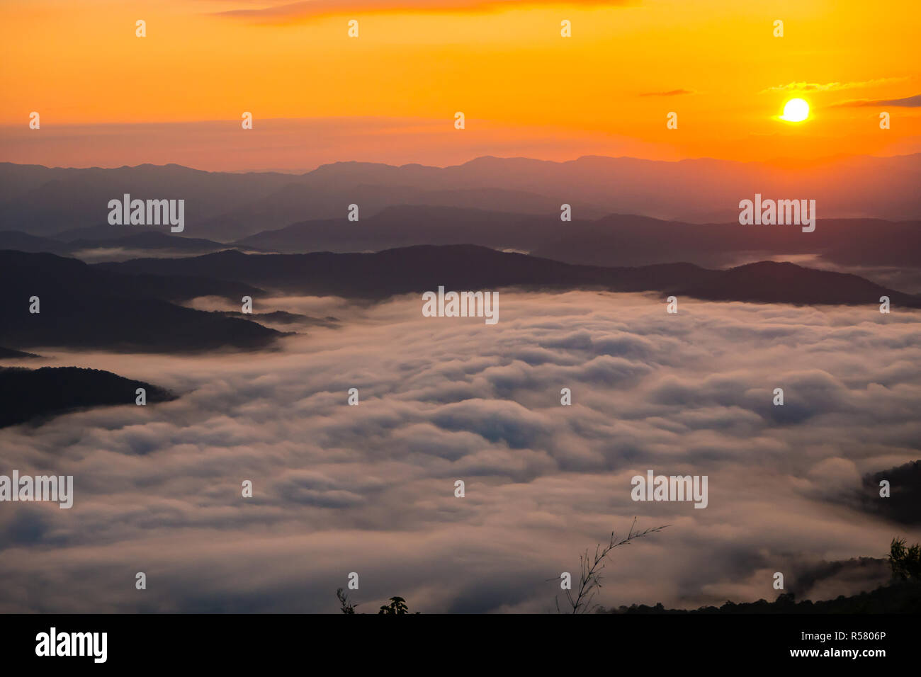 sunset overlooking mountains with Mist Stock Photo - Alamy