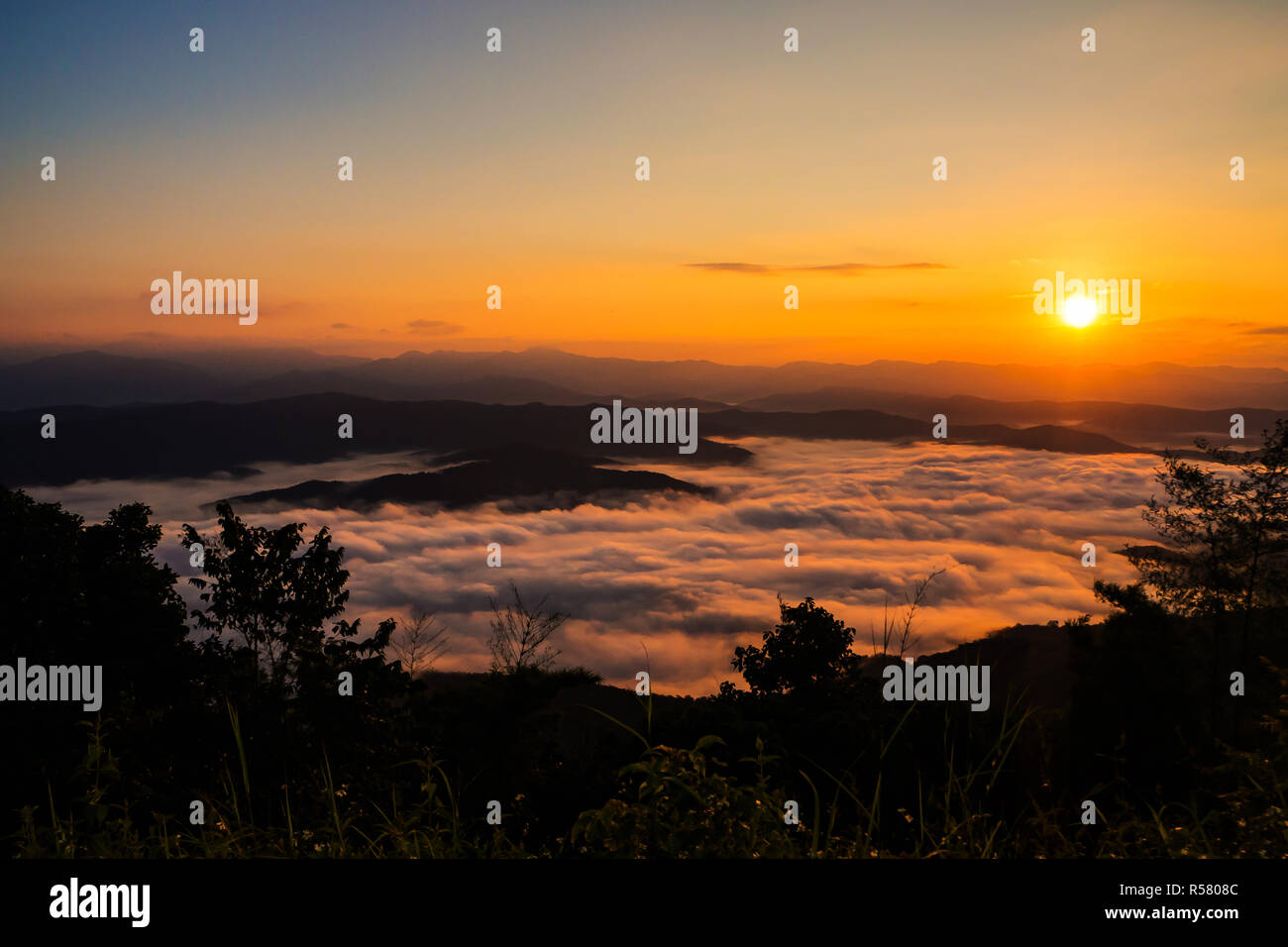 sunset overlooking mountains with Mist Stock Photo - Alamy