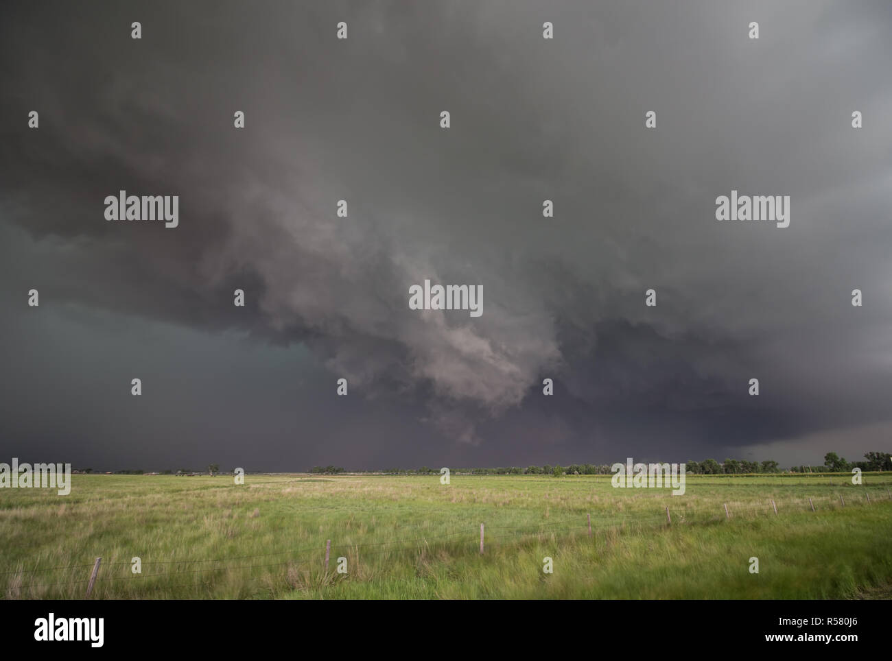 A rotating wall cloud hangs ominously under the base of a tornado ...