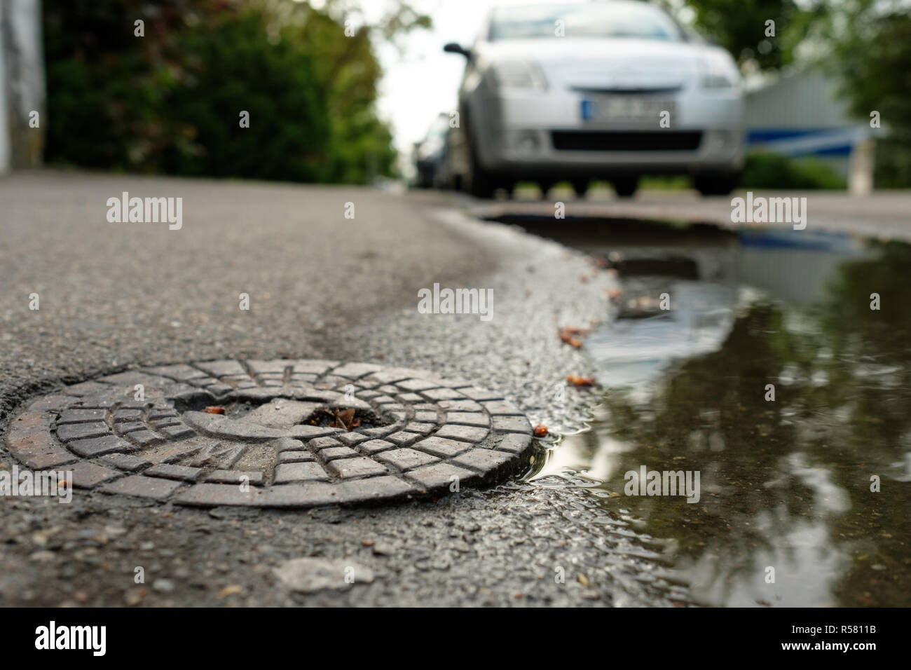metal measuring point on a walkway with puddle Stock Photo - Alamy