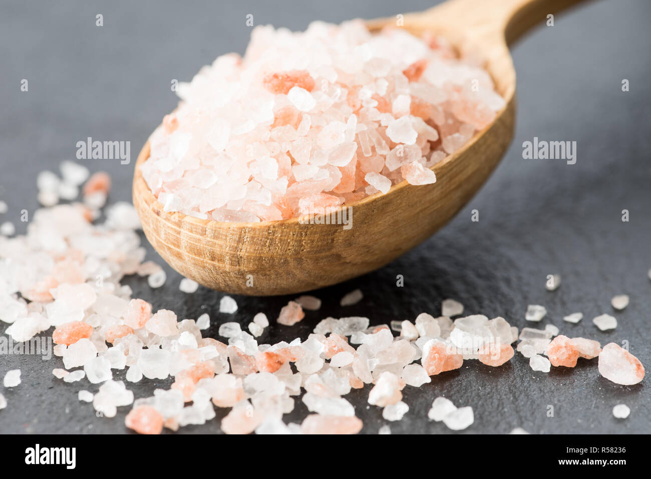 Himalayan pink crystal salt. spoon of pink himalayan salt on slate ...
