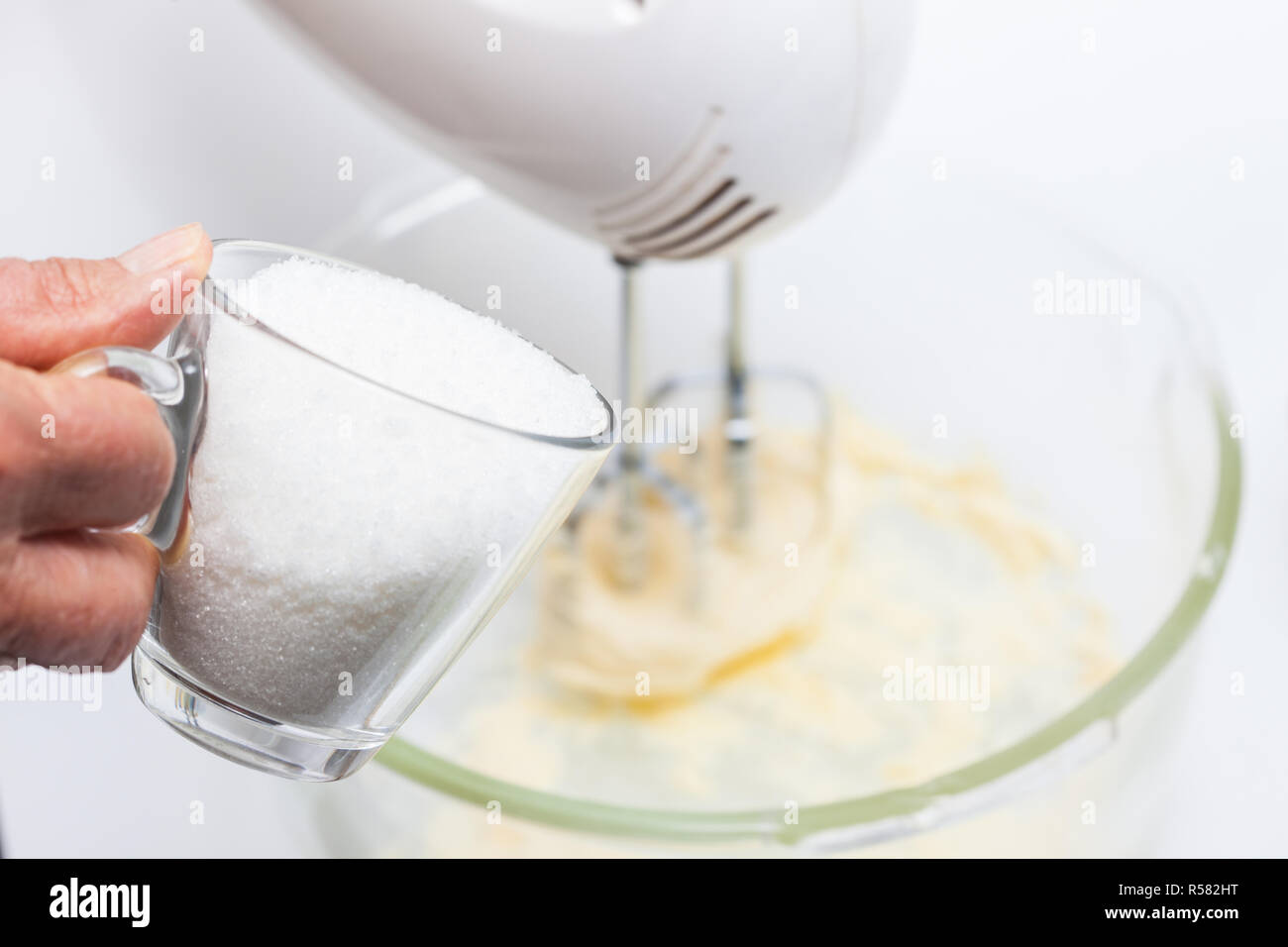 Adding sugar to butter for dough preparation Stock Photo - Alamy