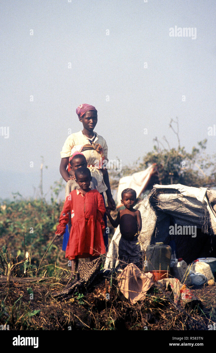 1994 - A Rwandan family pose in front of their makeshift home. The ...
