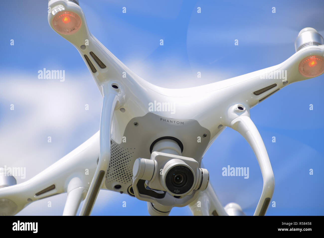 Drone DJI Phantom 4 in flight. Quadrocopter against the blue sky with ...