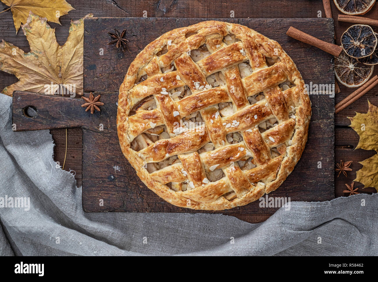 Baked whole round apple pie on a rectangular old brown board, wooden ...