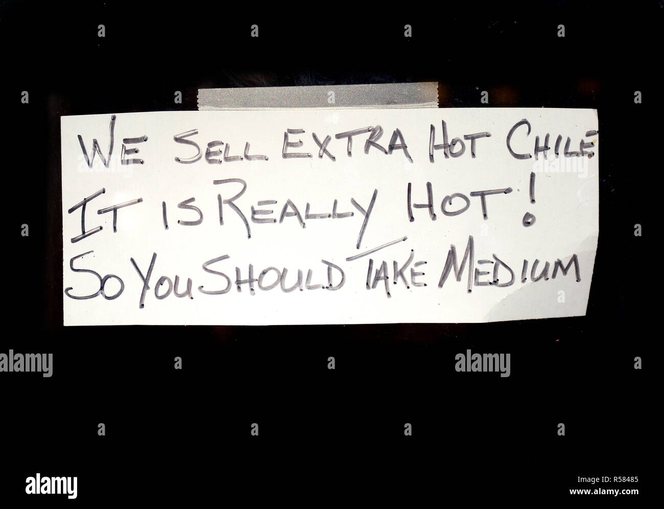 Warning sign at a store that sells hot Chile peppers Stock Photo - Alamy