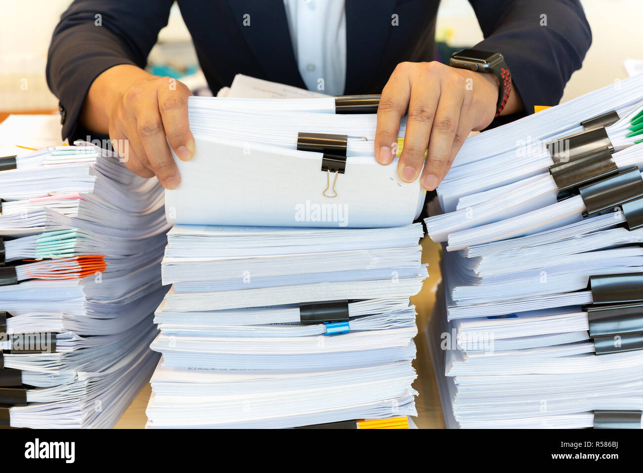 Businessman in suit look through pile of documents in office Stock ...
