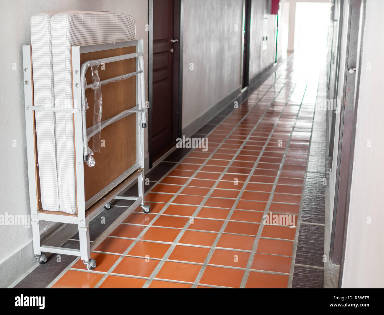 Reserve folding extra bed in front of room on the walkway in hotel ...