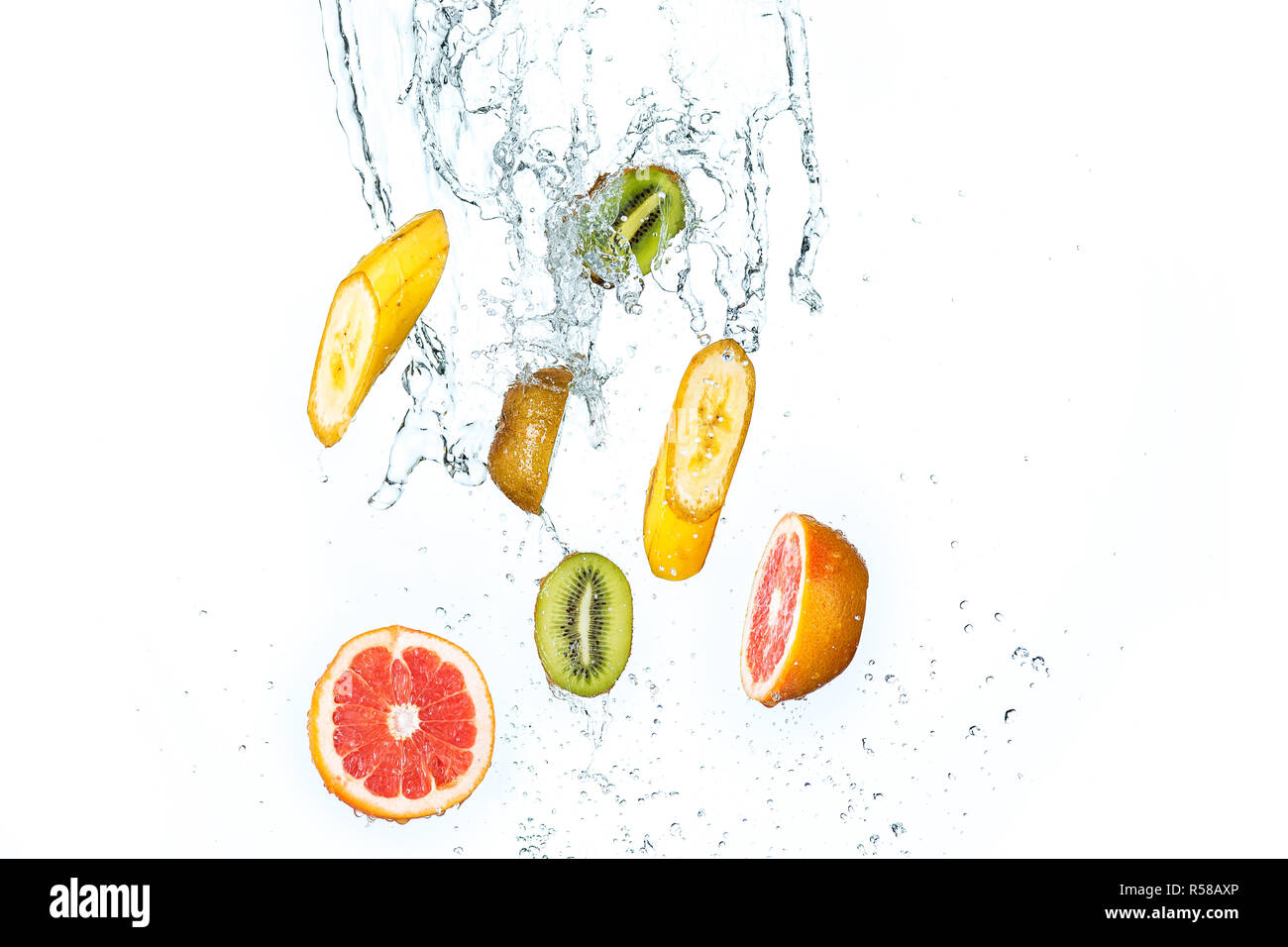 Fresh fruits falling in water splash, isolated on white background ...
