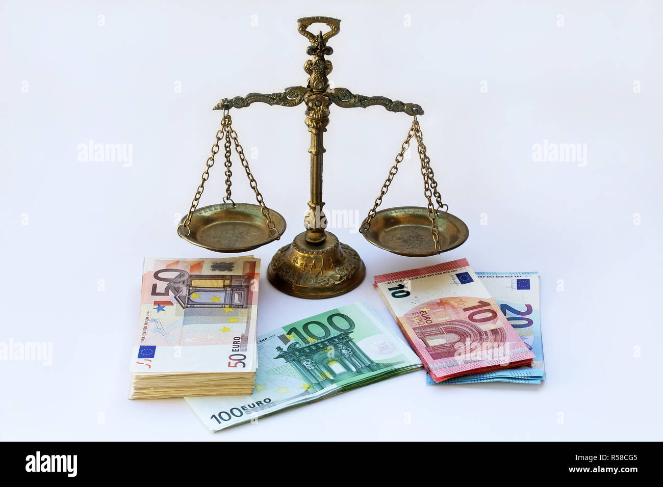 euro bills in front of a balance. how safe is the euro Stock Photo - Alamy