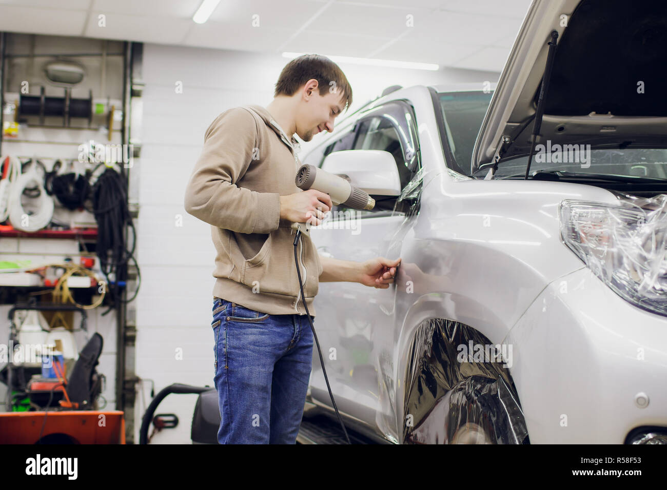 Worker hands installs car paint protection film Stock Photo - Alamy