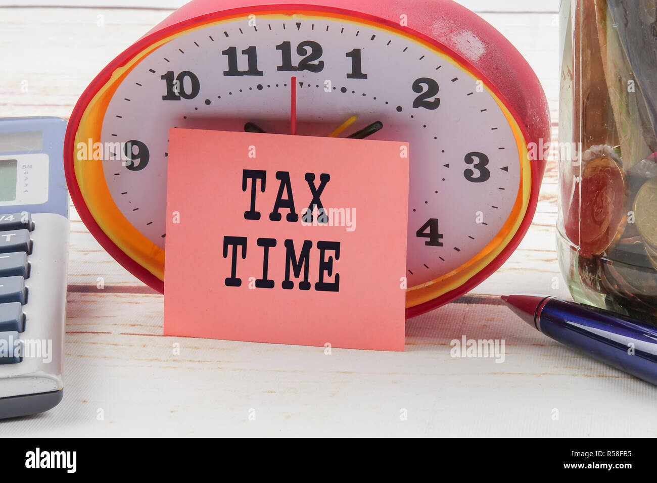 TAX DAY CONCEPT; Clock,red note,calculator and coins in the mason jar ...