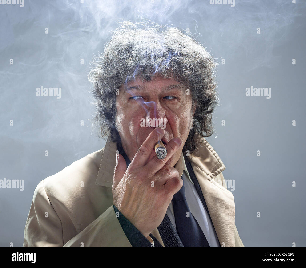 The senior man with cigar as detective or boss of mafia on gray studio ...