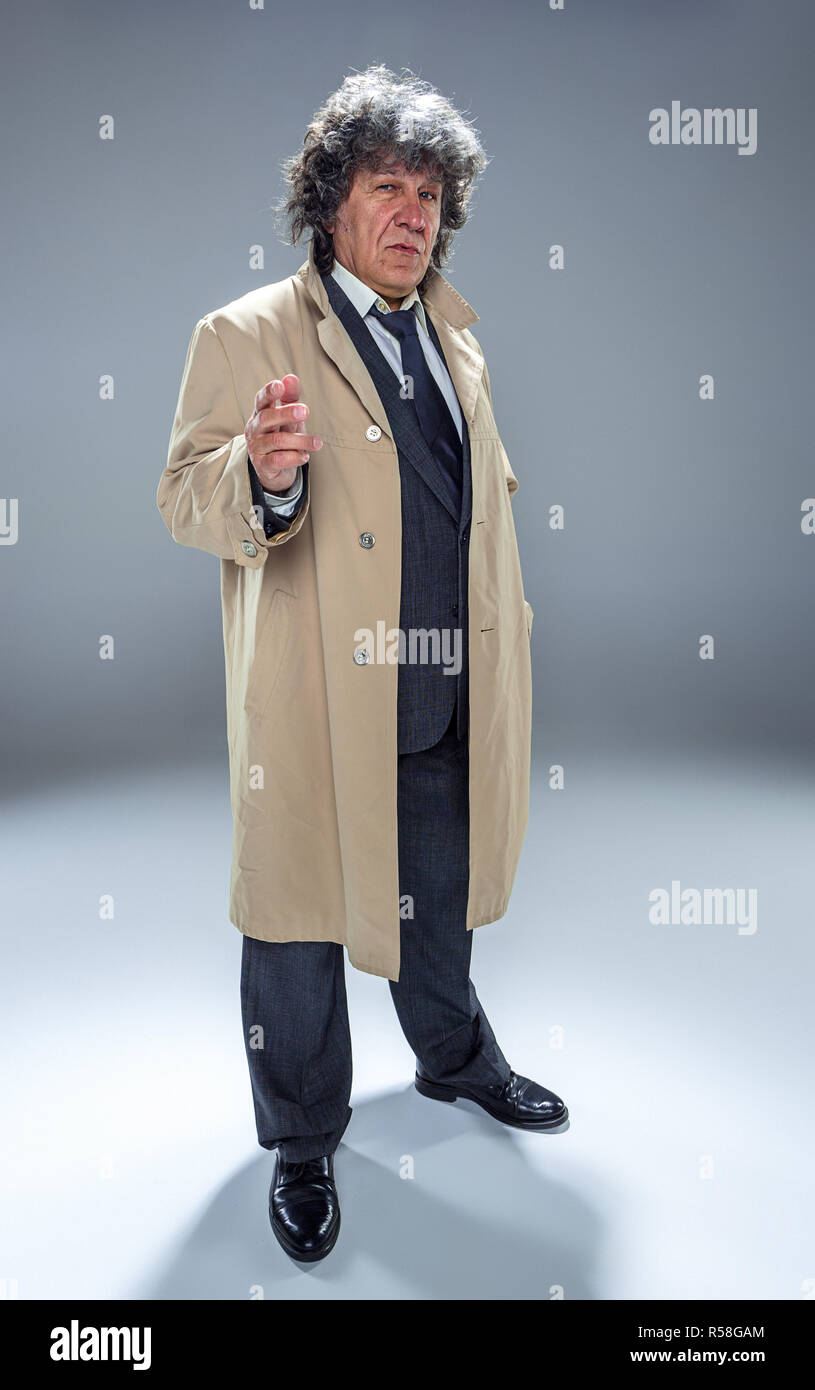 The senior man as detective or boss of mafia on gray studio background ...